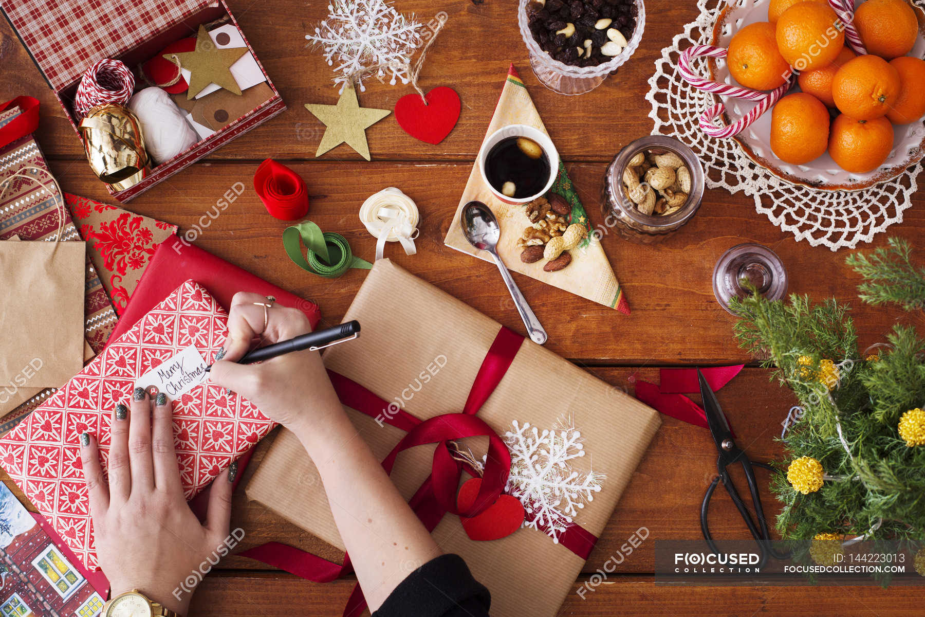 Hands writing on Christmas gift tag — fruit, spoon - Stock Photo ...