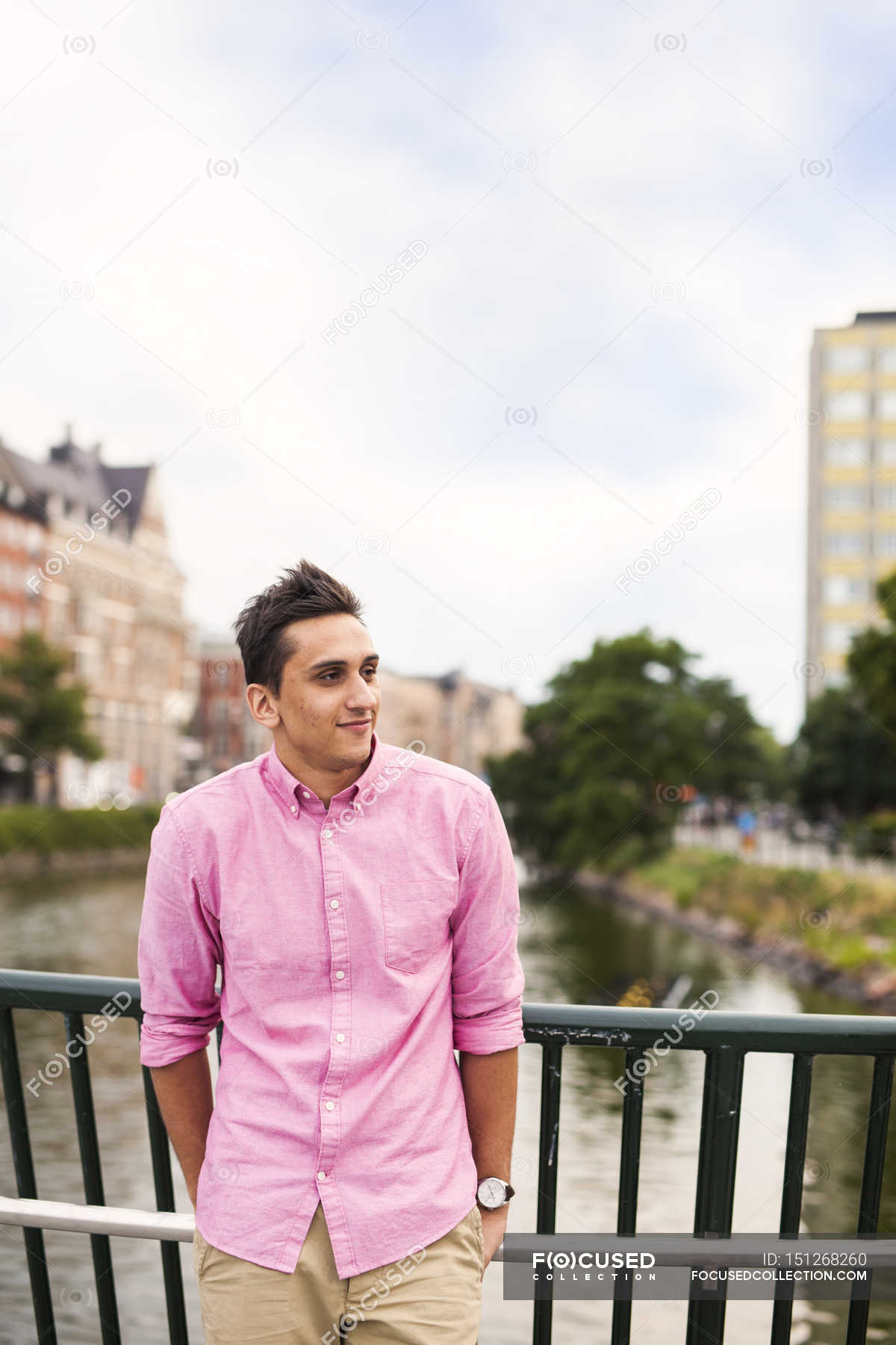 Smiling man standing by railing — outdoors, Front View - Stock Photo ...