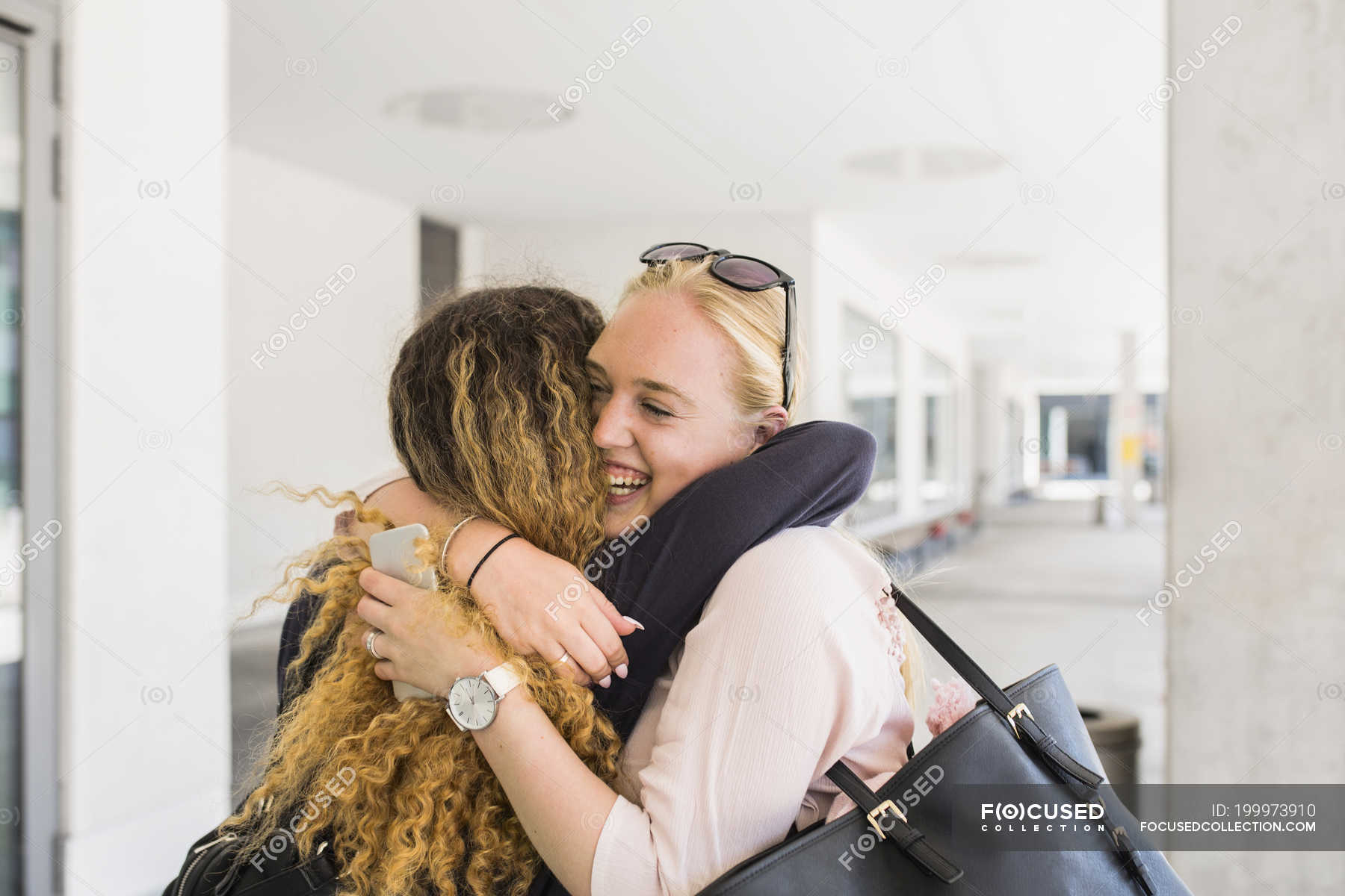Young women hugging each other — Building Exterior, Blonde Hair - Stock ...