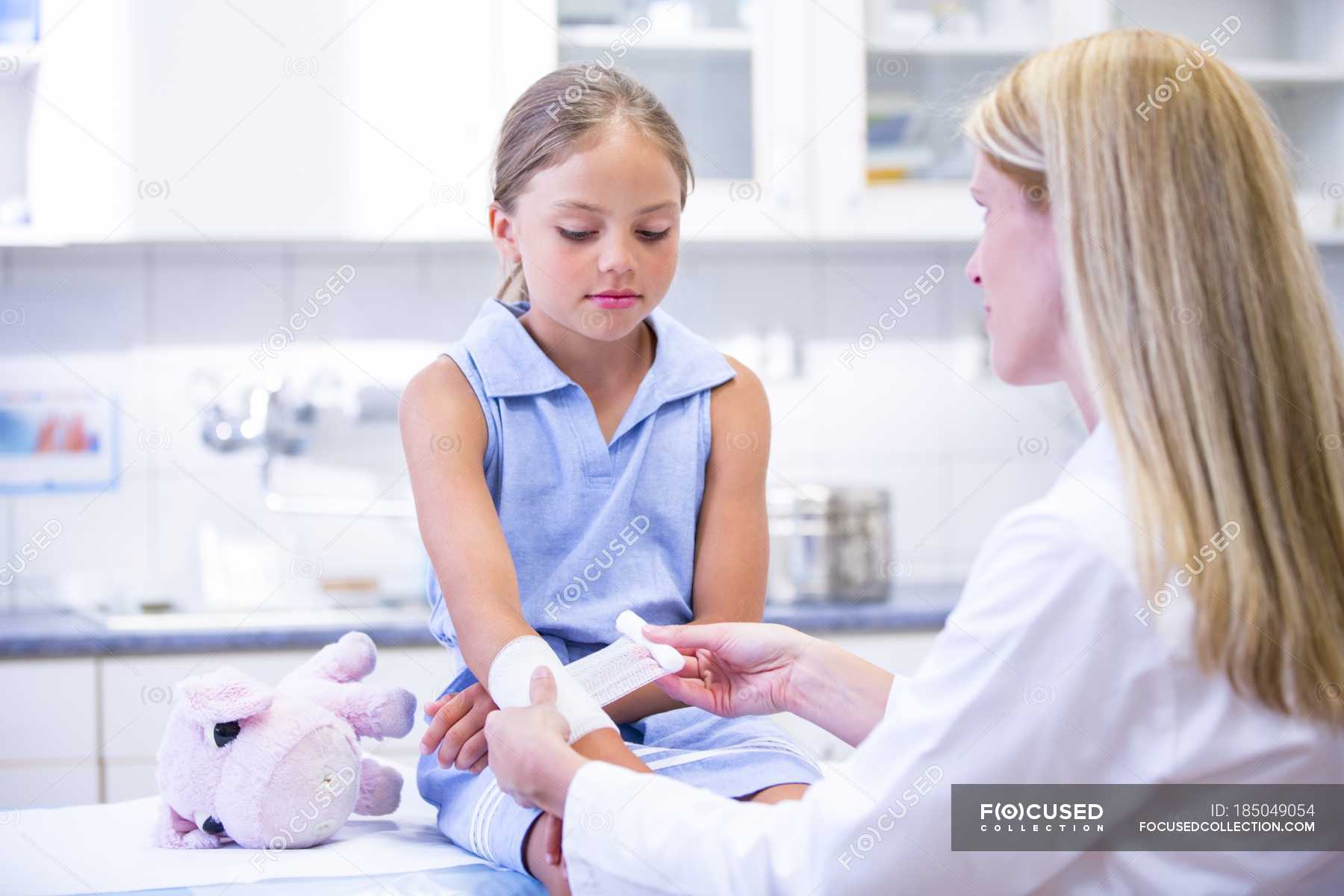 Nurse Applying Bandage To Elementary Age Girl Arm — Equipment Medical