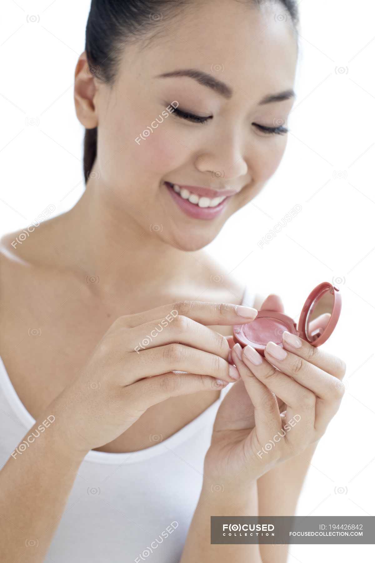 Young Chinese woman applying blusher on white background. — one person, cosmetics - Stock Photo ...