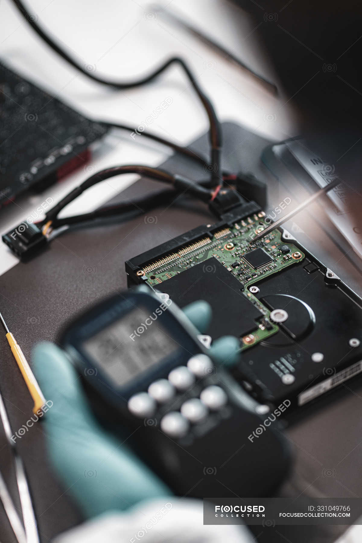 Close-up of digital forensic expert examining computer hard drive in ... Close-up of digital forensic expert examining computer hard drive in ...