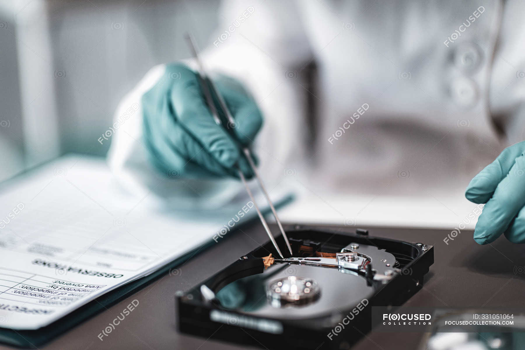 Female digital forensic expert examining computer hard drive with ... Female digital forensic expert examining computer hard drive with ...