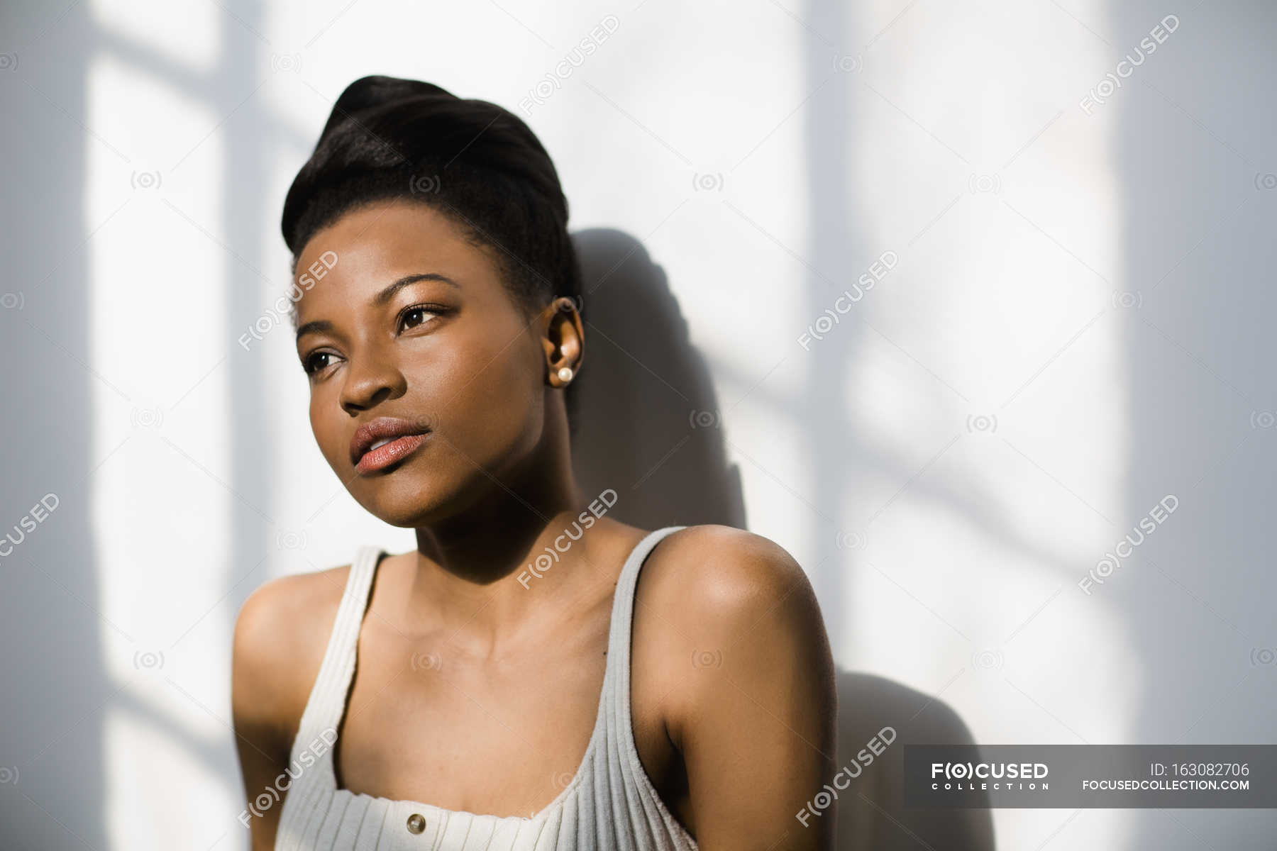 African Canadian woman leaning against wall — sunlight, confidence ...