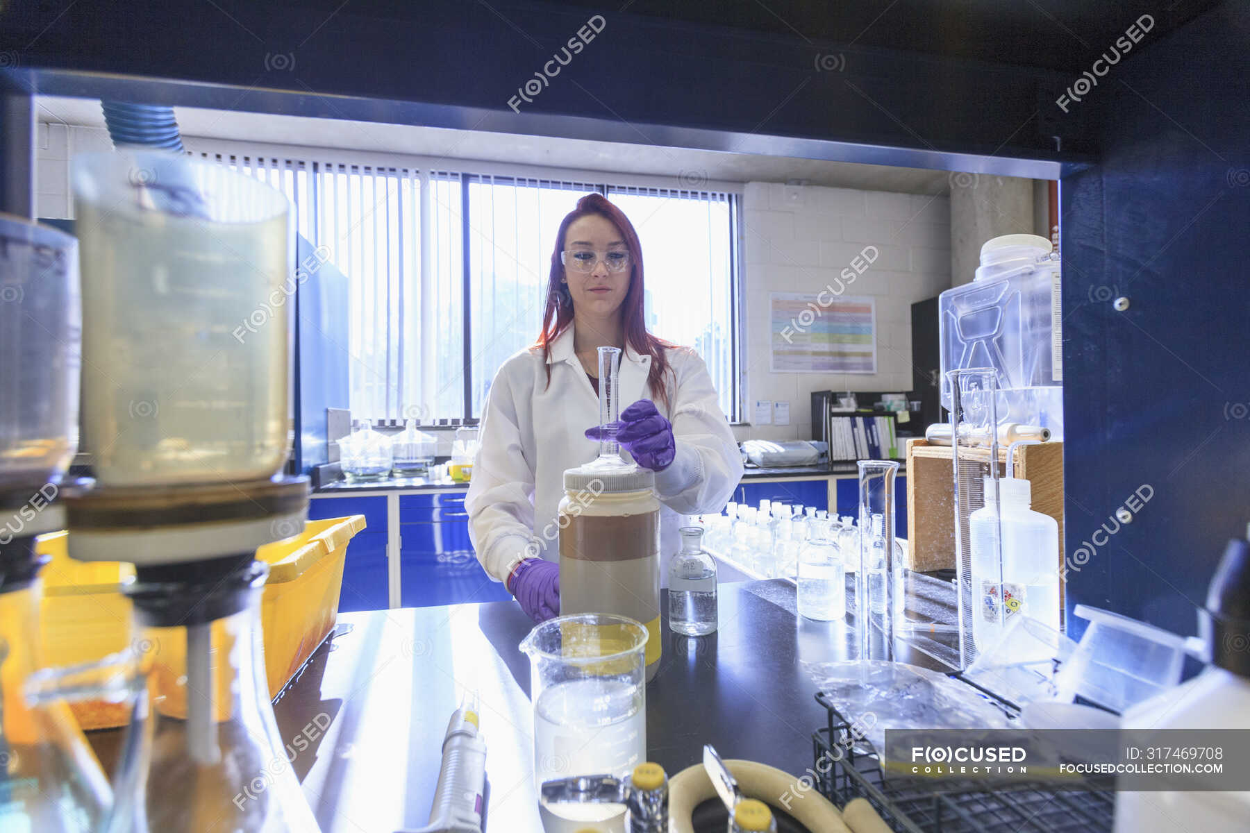 Lab chemist preparing graduated cylinder for standard solution ... Lab chemist preparing graduated cylinder for standard solution ...