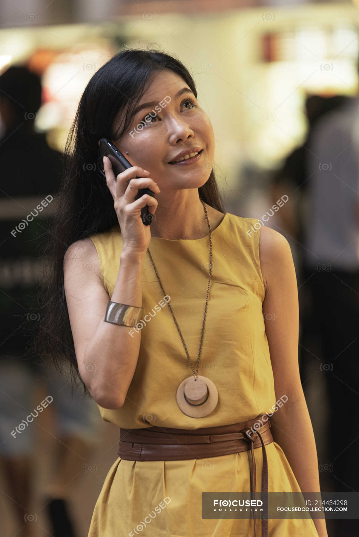Happy asian young woman talking on smartphone — handphone, earrings ... Happy asian young woman talking on smartphone — handphone, earrings ...