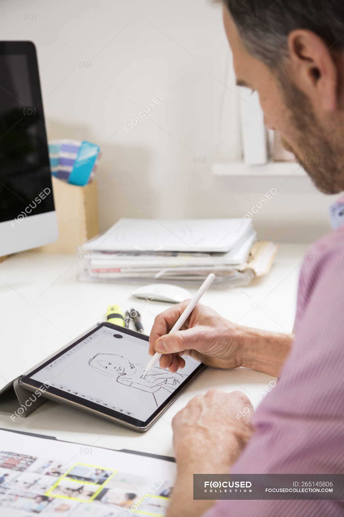 Mann Am Schreibtisch Im B ro Zeichnet Weibliche Figur Auf Tablet Digital Unternehmen Stock mann-am-schreibtisch-im-b-ro-zeichnet-weibliche-figur-auf-tablet-digital-unternehmen-stock