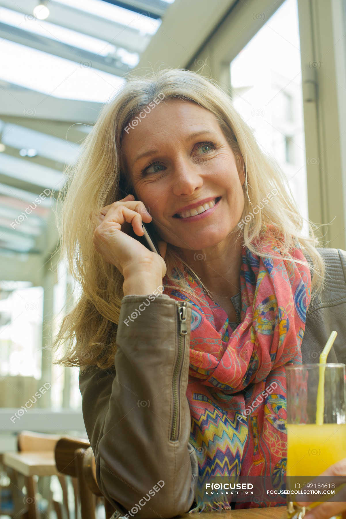 Mature Woman Talking On Cell Phone And Smiling In Cafe — Caucasian