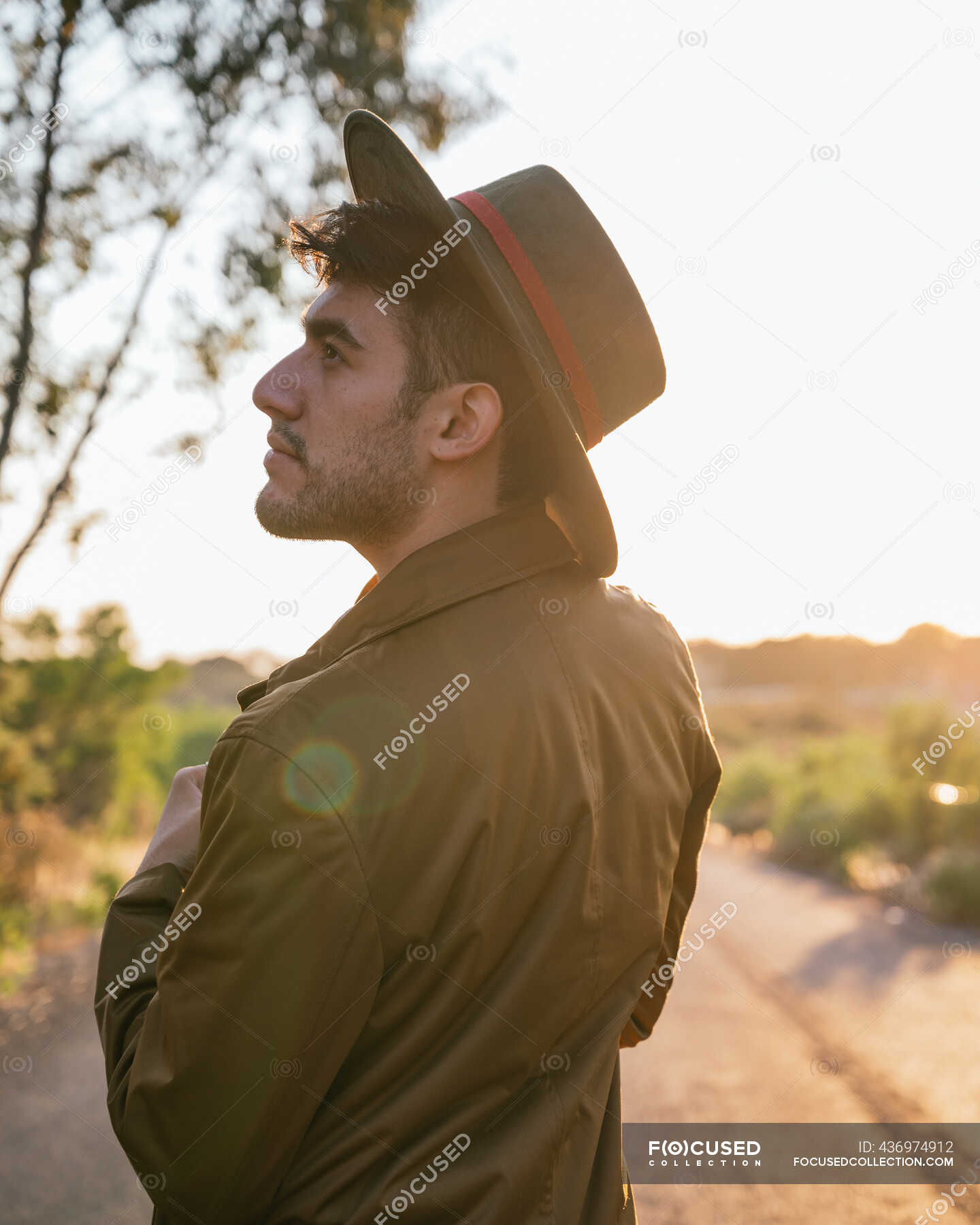 Handsome explorer man standing on road and enjoying of sunrise at natu ...