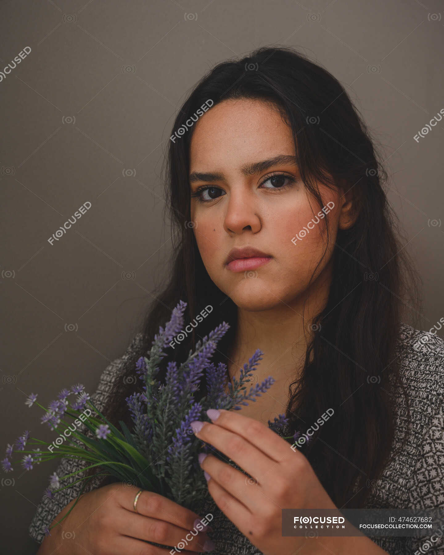 Portrait of a young beatiful hispanic woman on a grey background — one ... Portrait of a young beatiful hispanic woman on a grey background — one ...