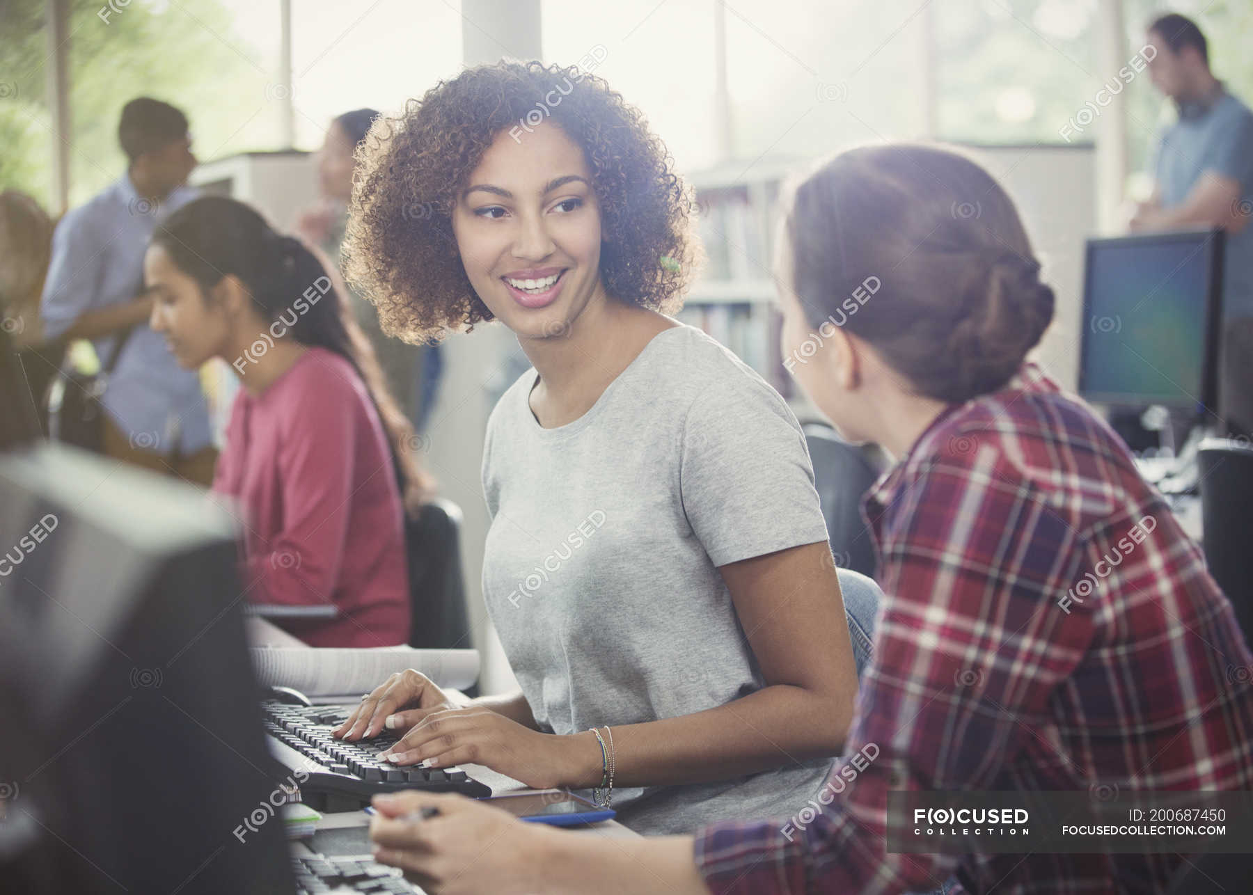 Female college students using computers in computer lab library ...