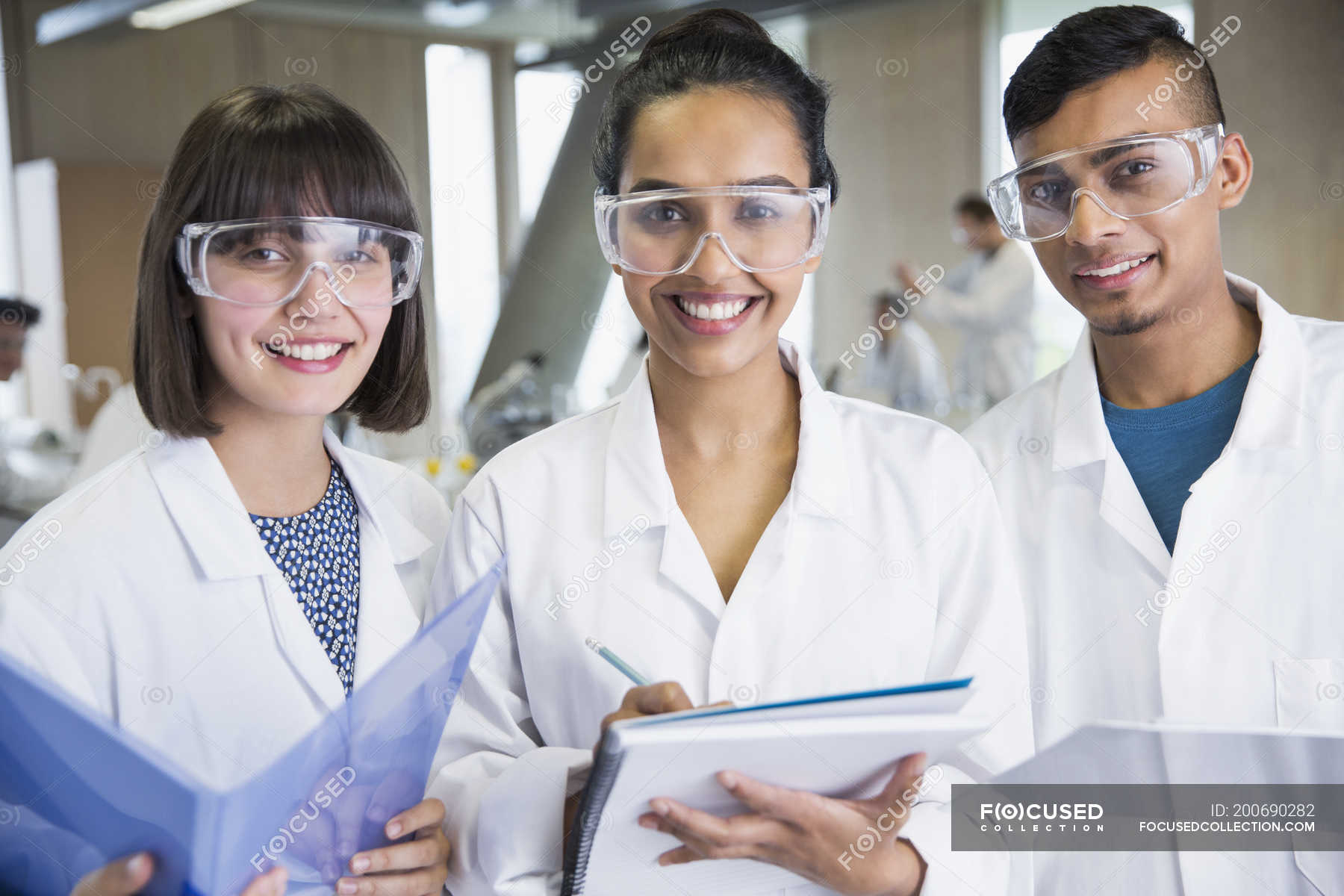 Portrait smiling college students in science lab coats — Focus On ...