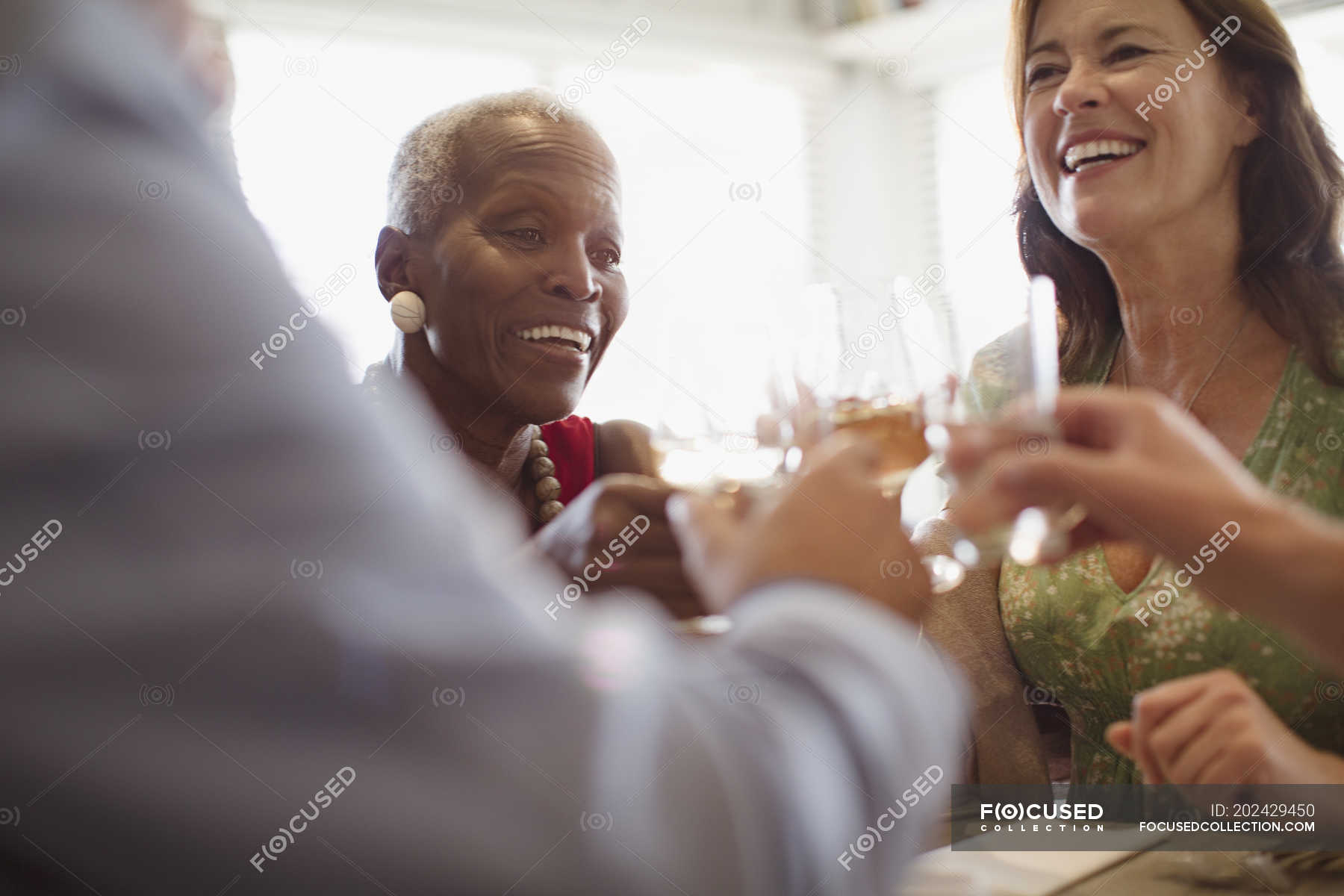 Smiling Mature Women Drinking Wine Dining At Restaurant — People