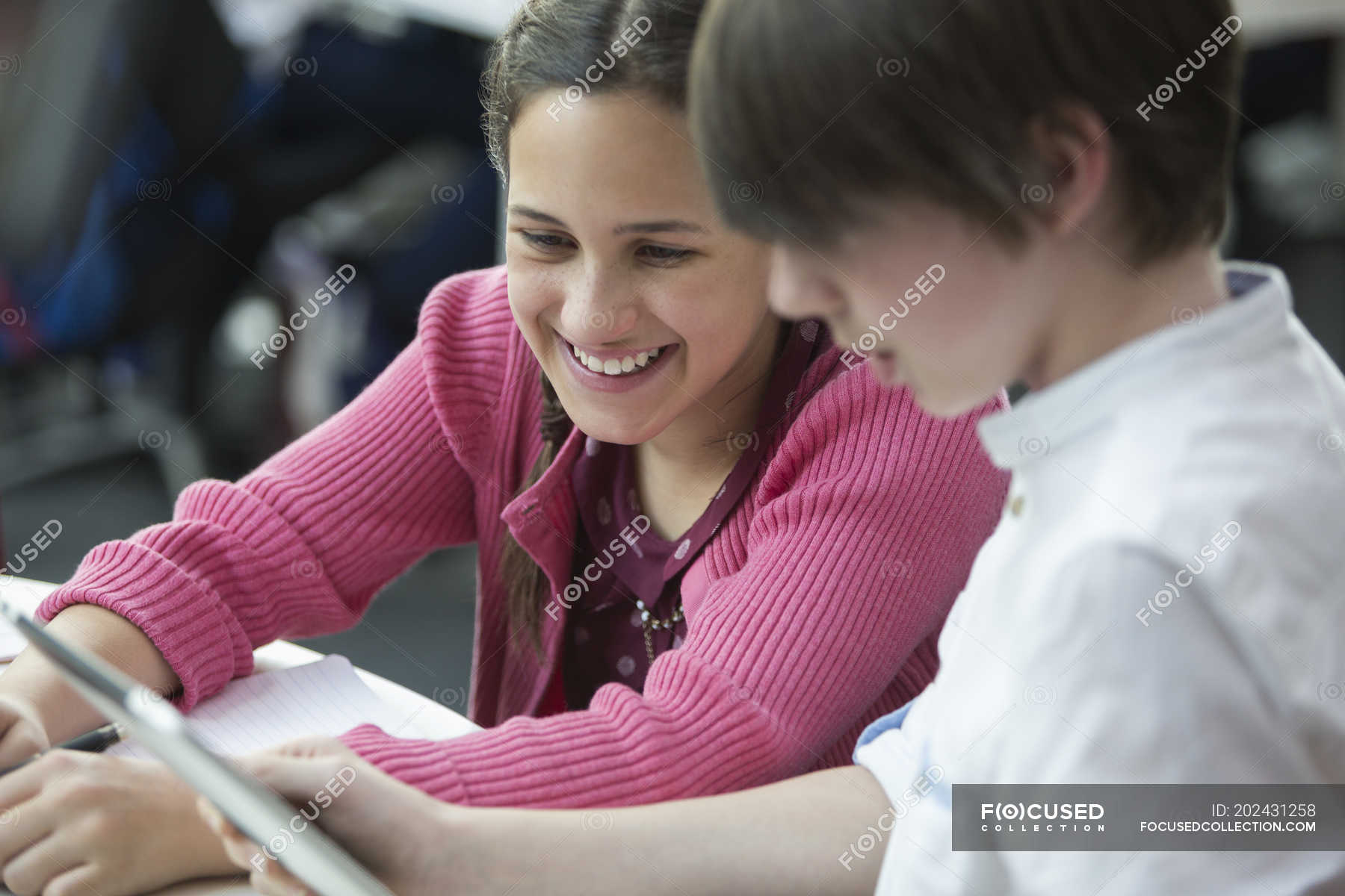 Smiling students using digital tablet in classroom — secondary school ...