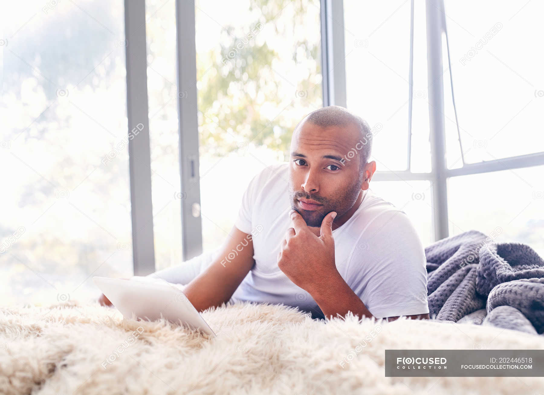 Portrait serious handsome man using digital tablet on bed — internet ... Portrait serious handsome man using digital tablet on bed — internet ...