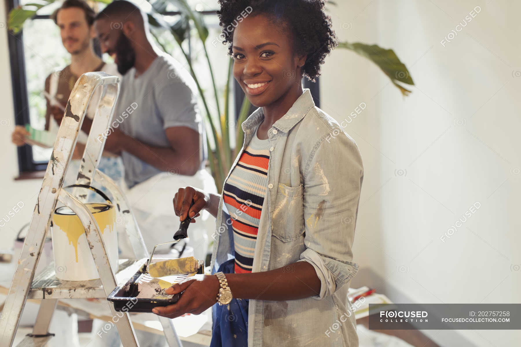 Portrait smiling, confident woman painting living room — standing ... Portrait smiling, confident woman painting living room — standing ...
