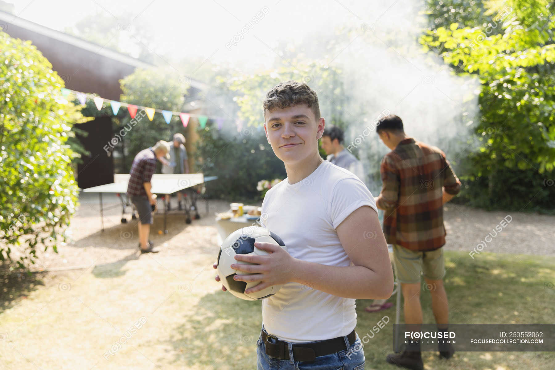 Portrait confident teenage boy with soccer ball, enjoying backyard ... Portrait confident teenage boy with soccer ball, enjoying backyard ...