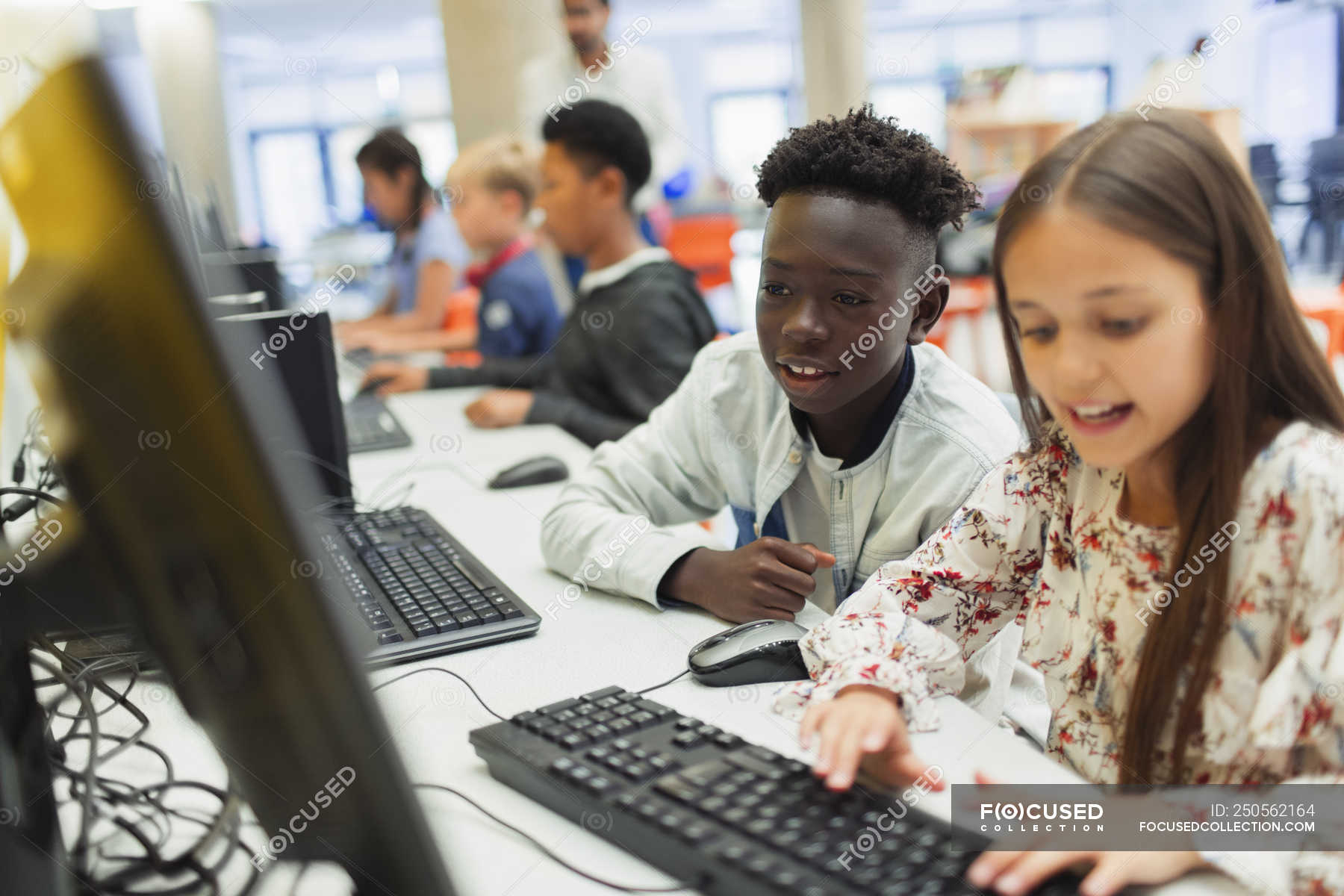 Junior high students using computer in computer lab — table, childhood ...