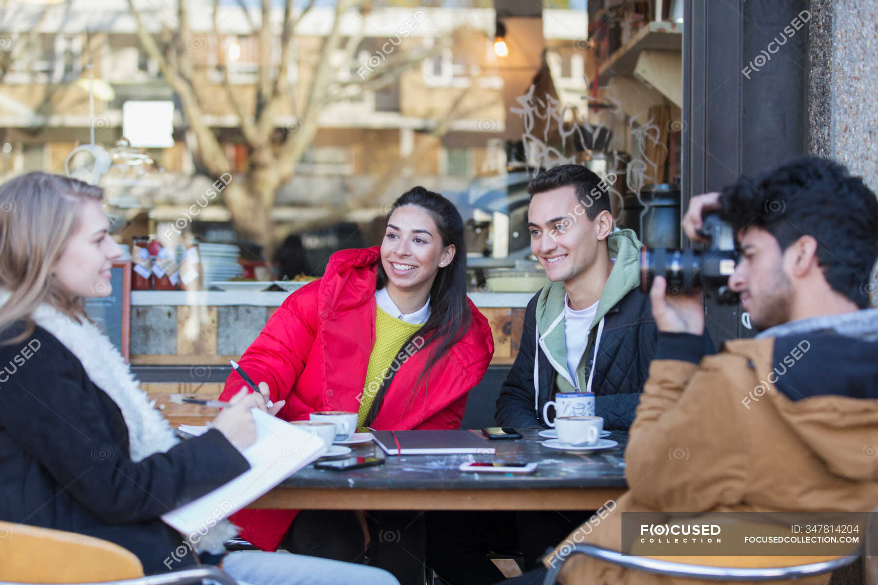 Young friends hanging out and studying at sidewalk cafe — togetherness ...