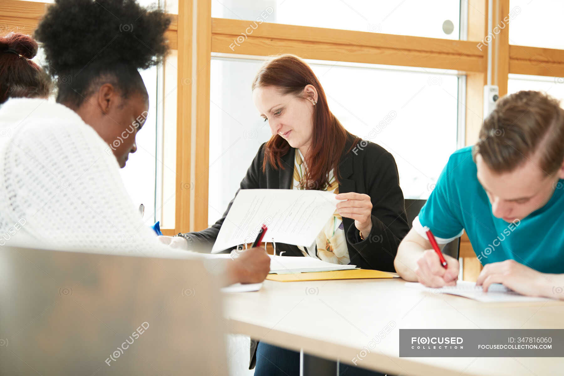 Dedicated college students studying in classroom — indoors, three ...