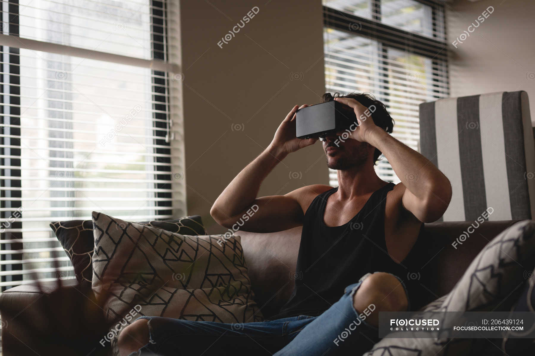Man using virtual reality headset in living room at home — 30 34 years ...