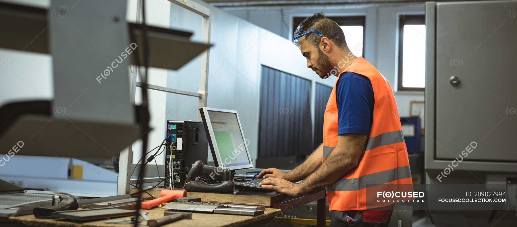 Male worker working on computer at factory — commercial, screen - Stock ...