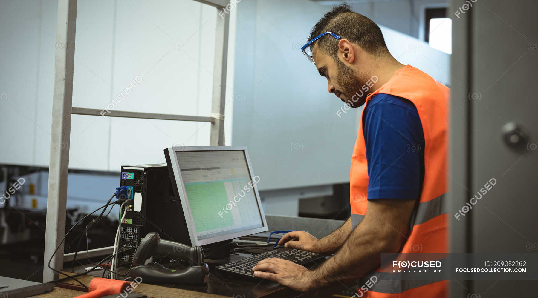 Male worker working on computer at factory — functioning, concentration ...