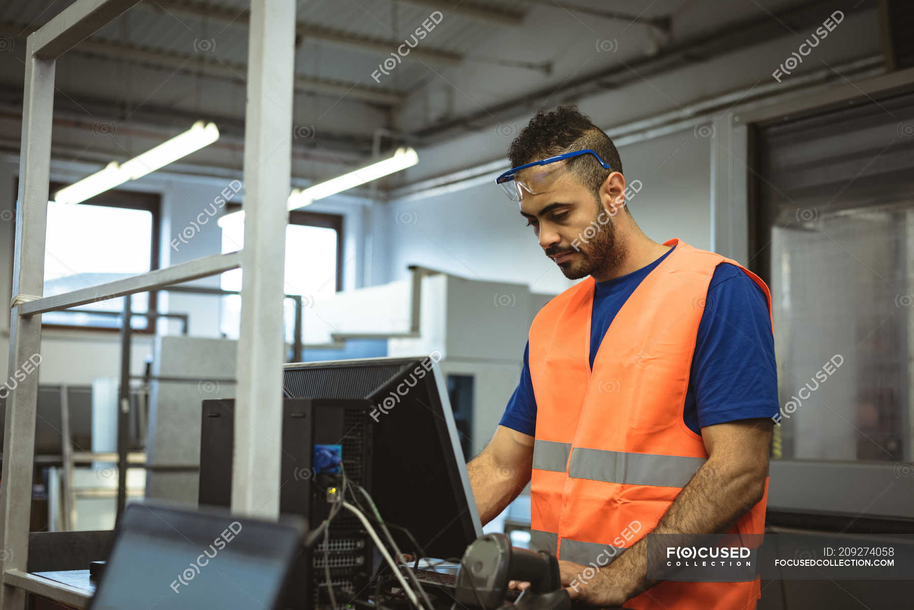 Male worker working on computer at factory — business, functioning ...