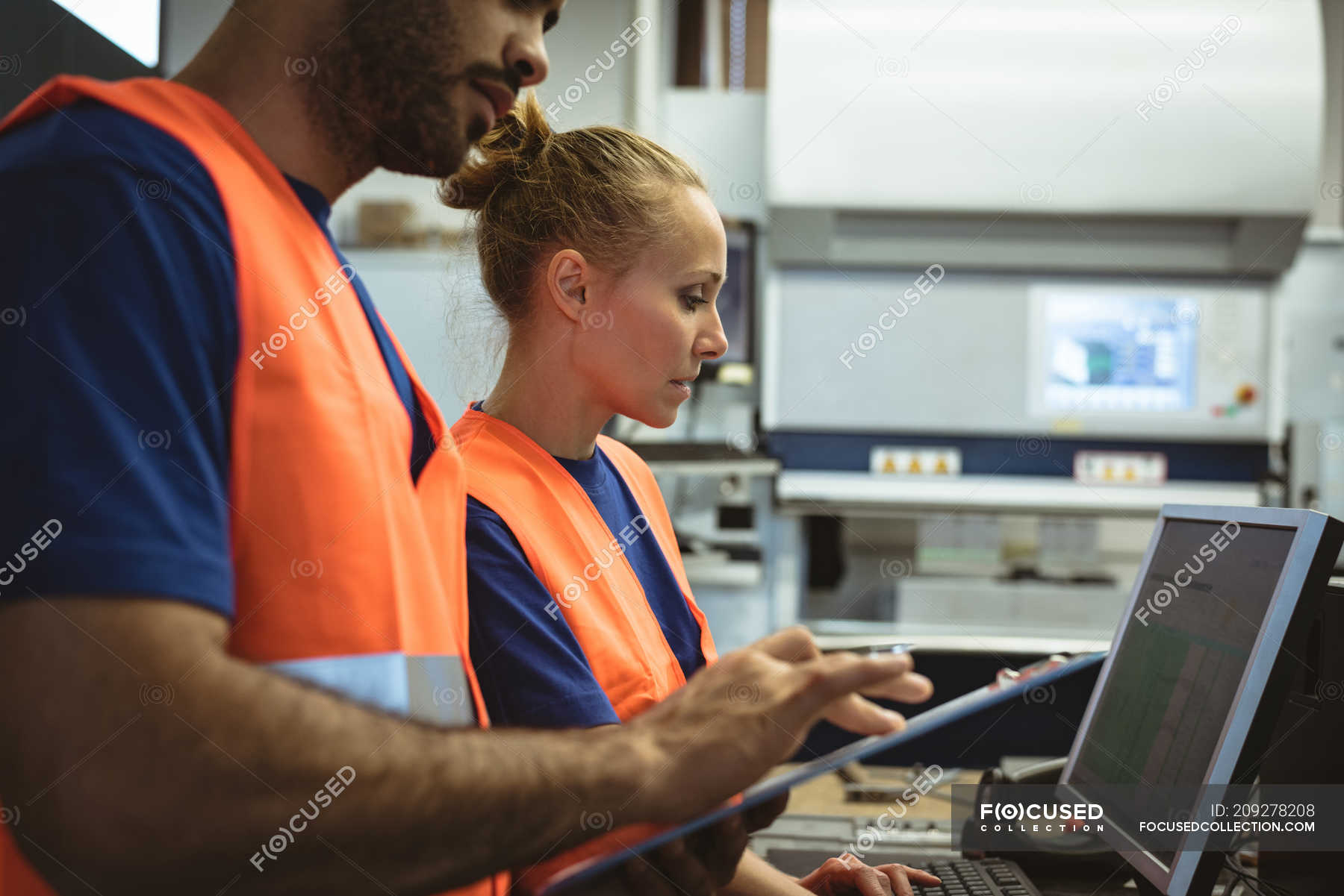Two workers working on computer in factory — commercial, laborer ...