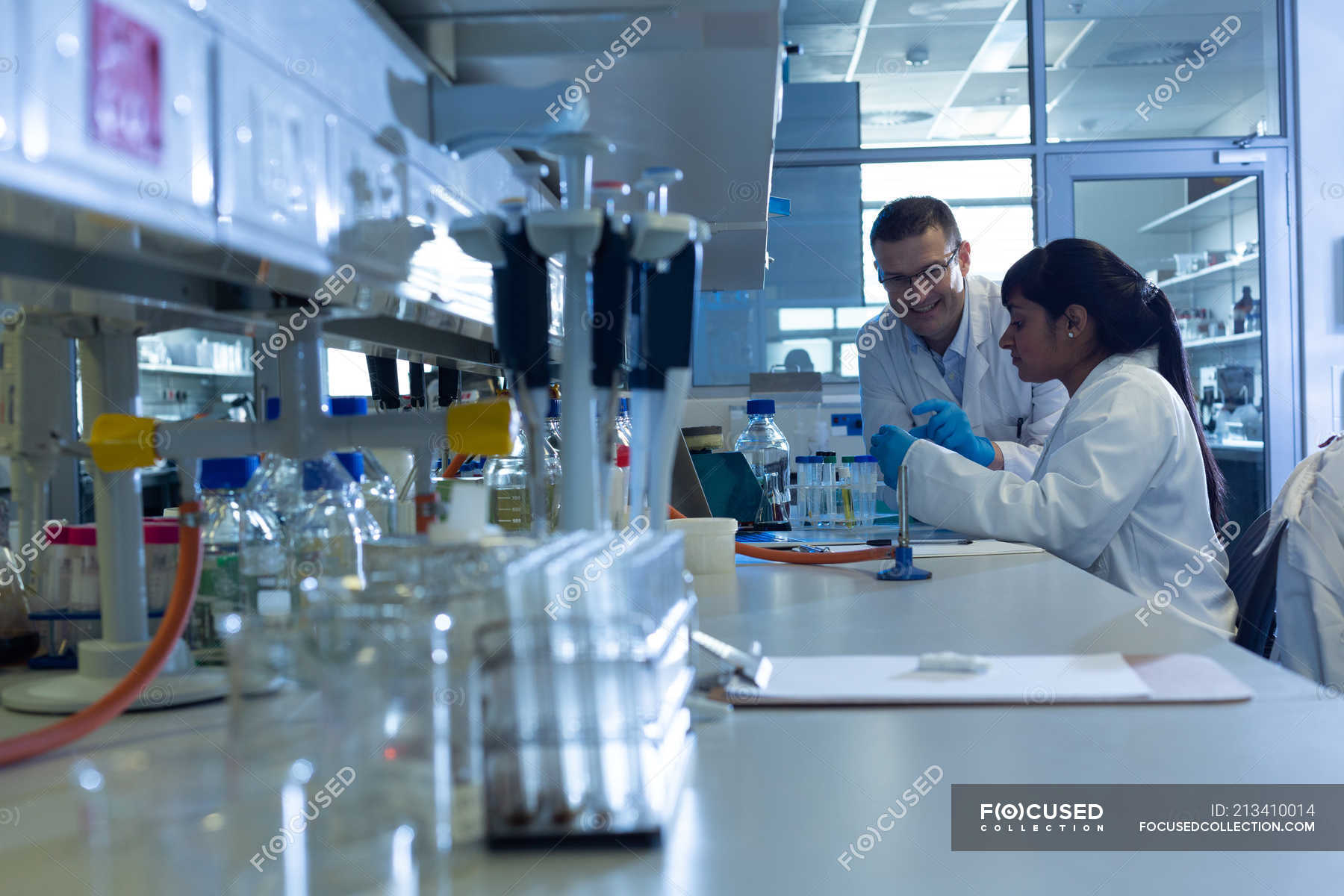 Scientists experimenting together in laboratory — experience, standing ... Scientists experimenting together in laboratory — experience, standing ...