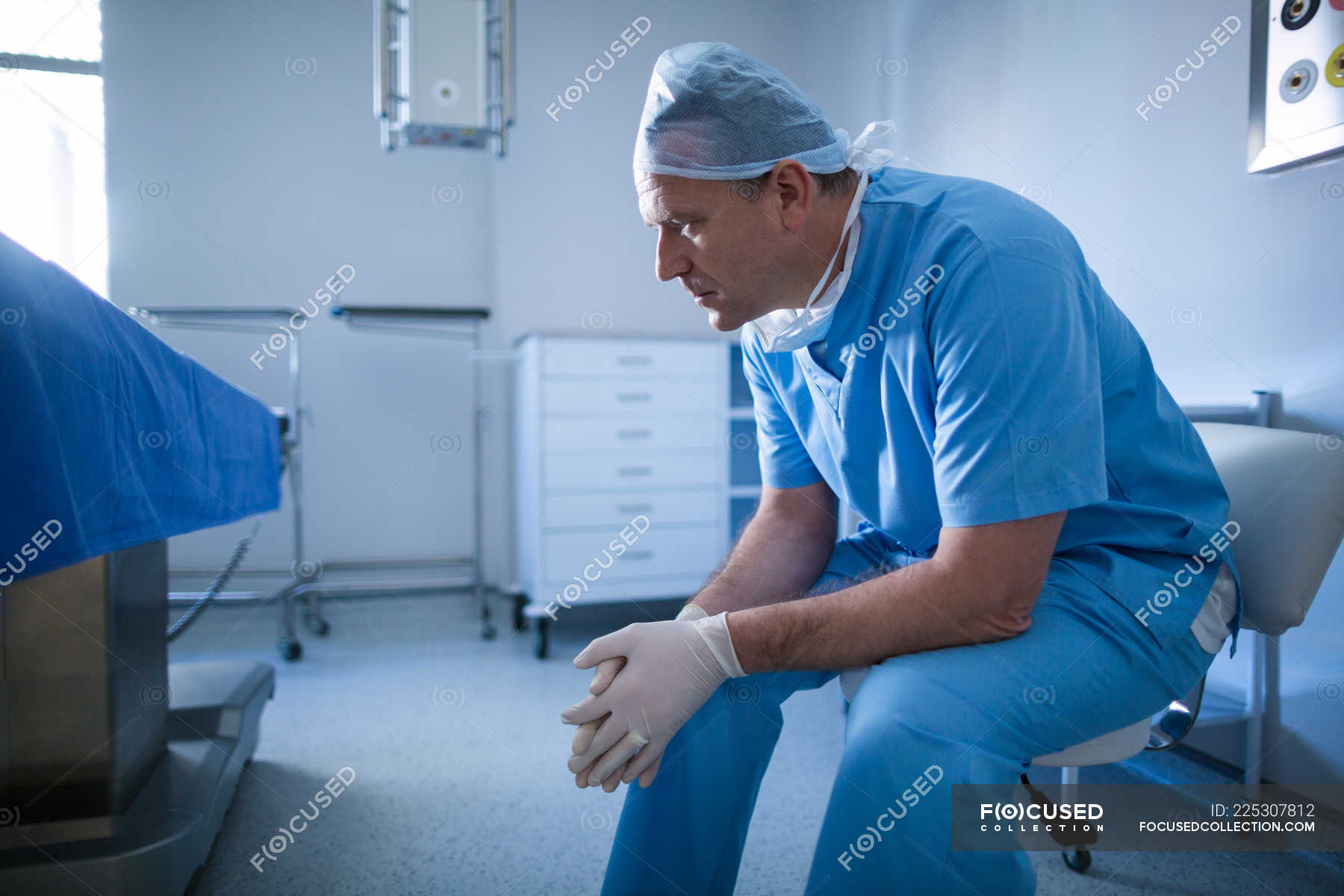 Male surgeon sitting on a chair at the hospital — thinking, doctor ... Male surgeon sitting on a chair at the hospital — thinking, doctor ...
