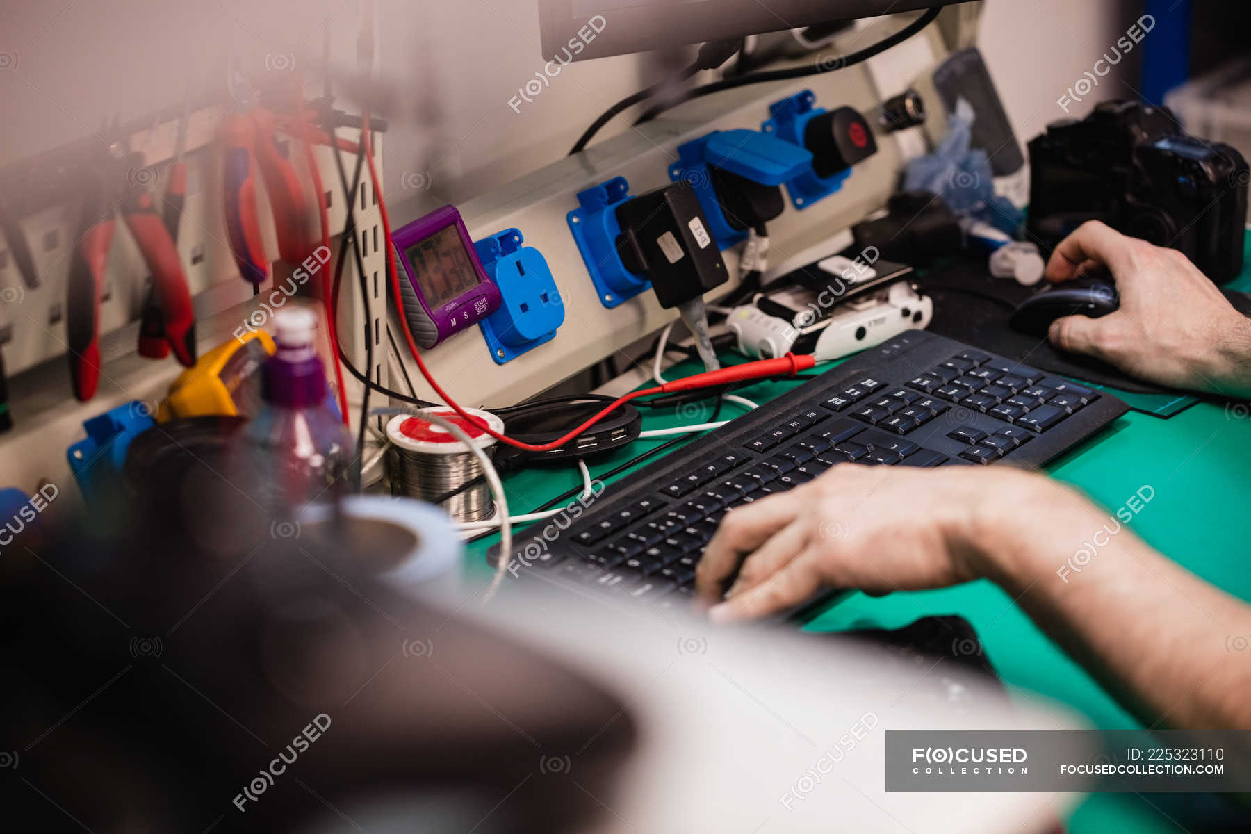 Close-up of a man working on desktop pc in an electronics repair centre ...
