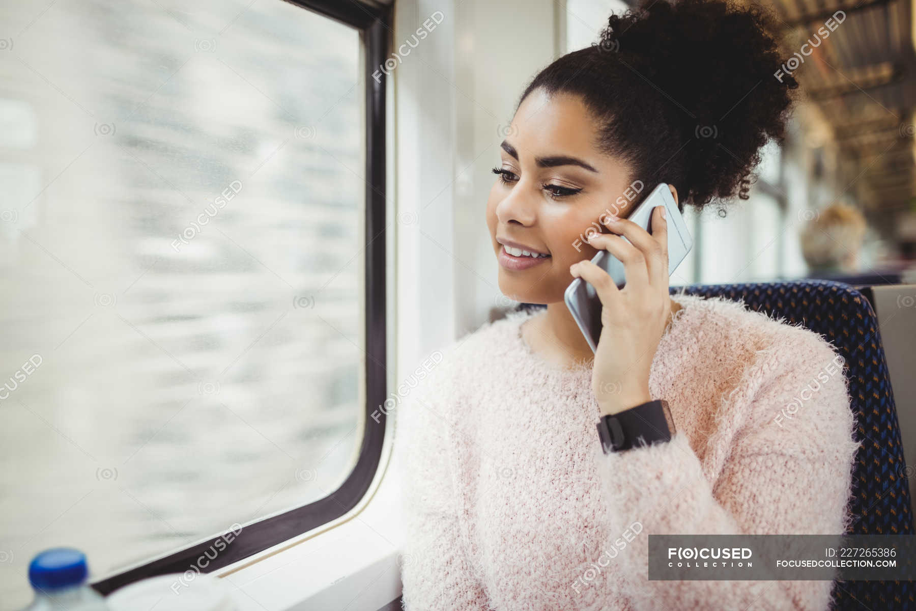 Smiling Woman Talking On Phone While Sitting In Train — Wireless