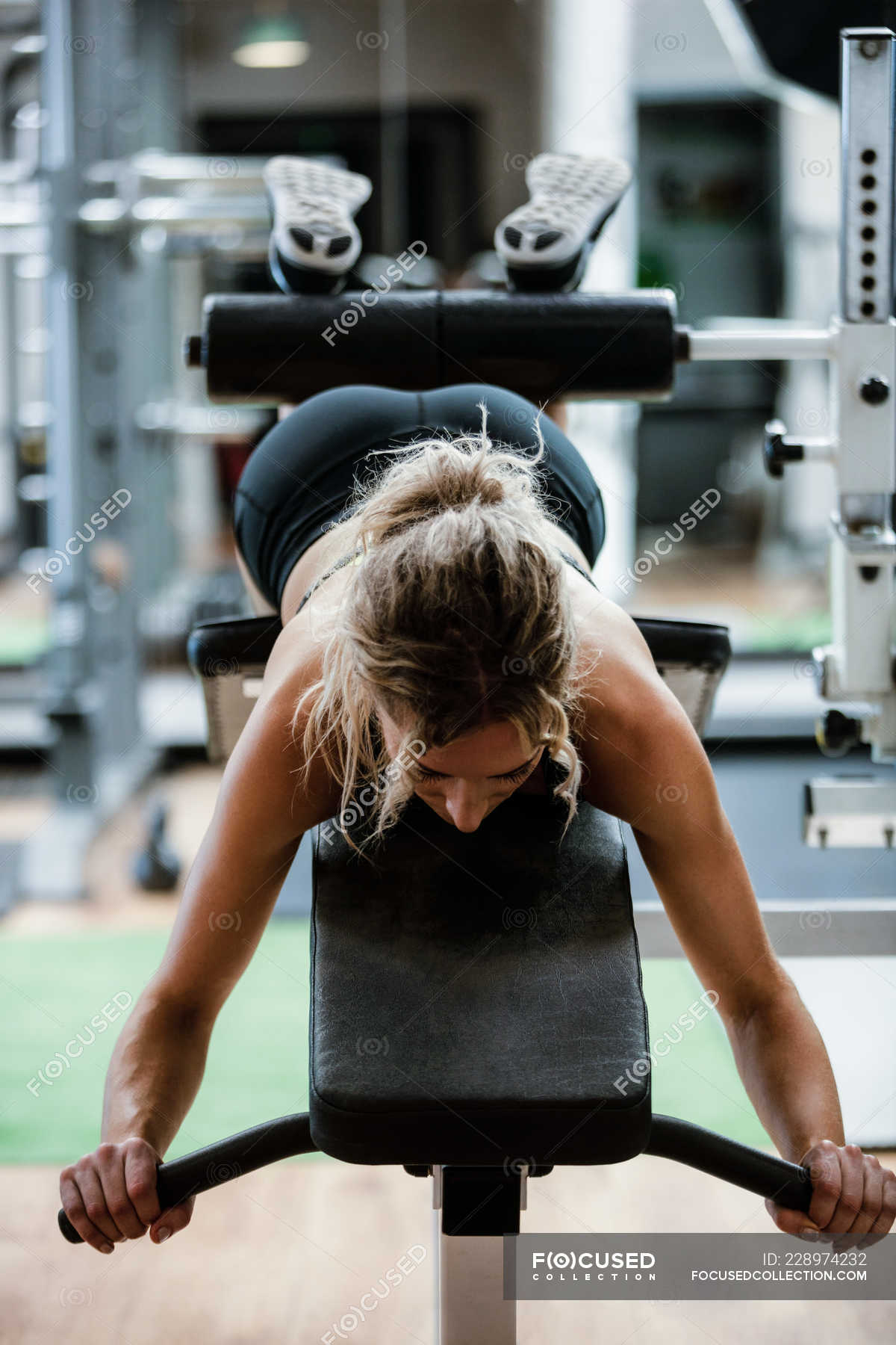 Woman performing exercise on bench press in gym — strength, routine ...