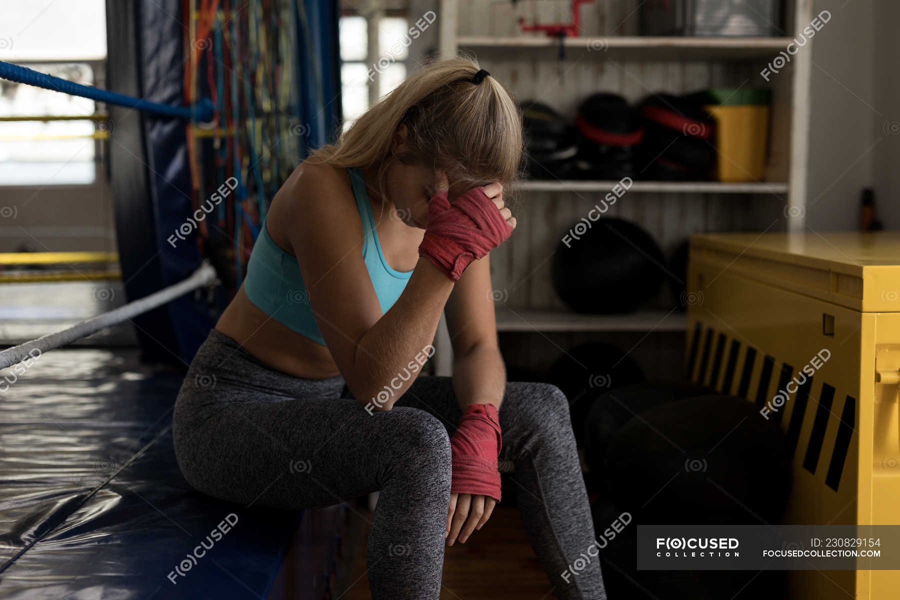 Tired female boxer relaxing in boxing ring at fitness studio — hand on head, hobby - Stock Photo ...