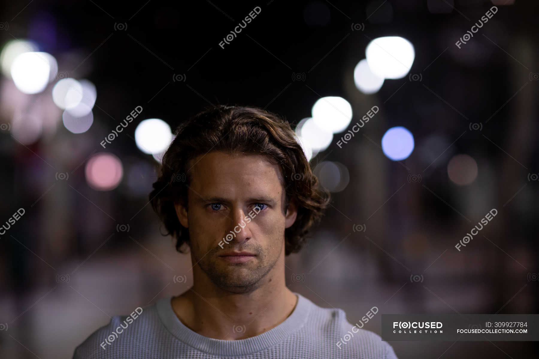 Portrait of a young Caucasian man in the street looking straight to ...