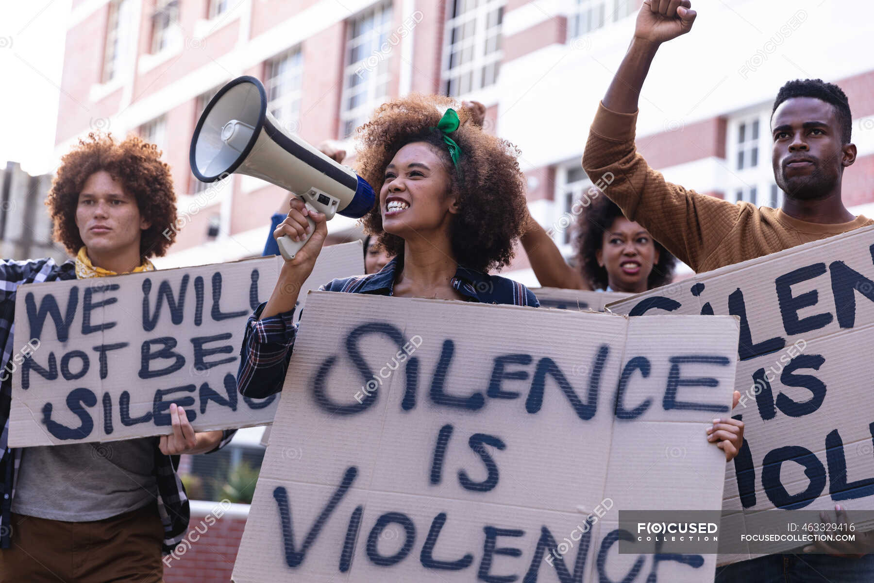 Diverse male and female protesters on march holding protest signs ...