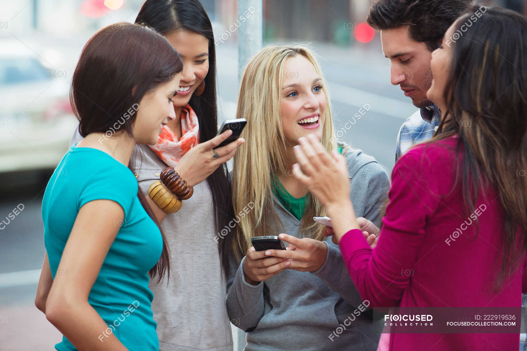 Friends using mobile phones outdoors — togetherness, highways - Stock ...