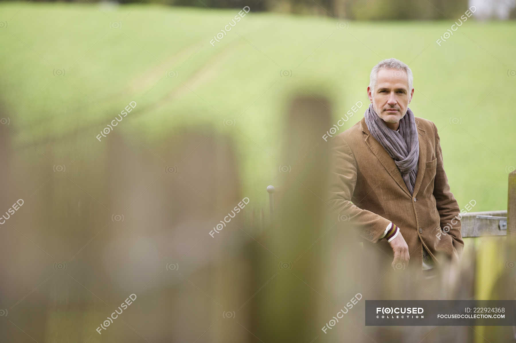 Elegant mature man leaning on fence in field — male, daytime - Stock ...