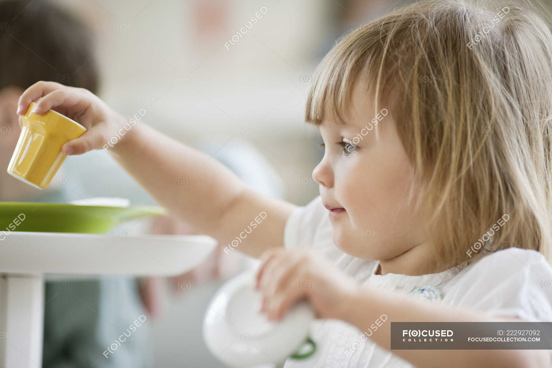 Cute little girl playing with toy tea set from dining table — tea party ...