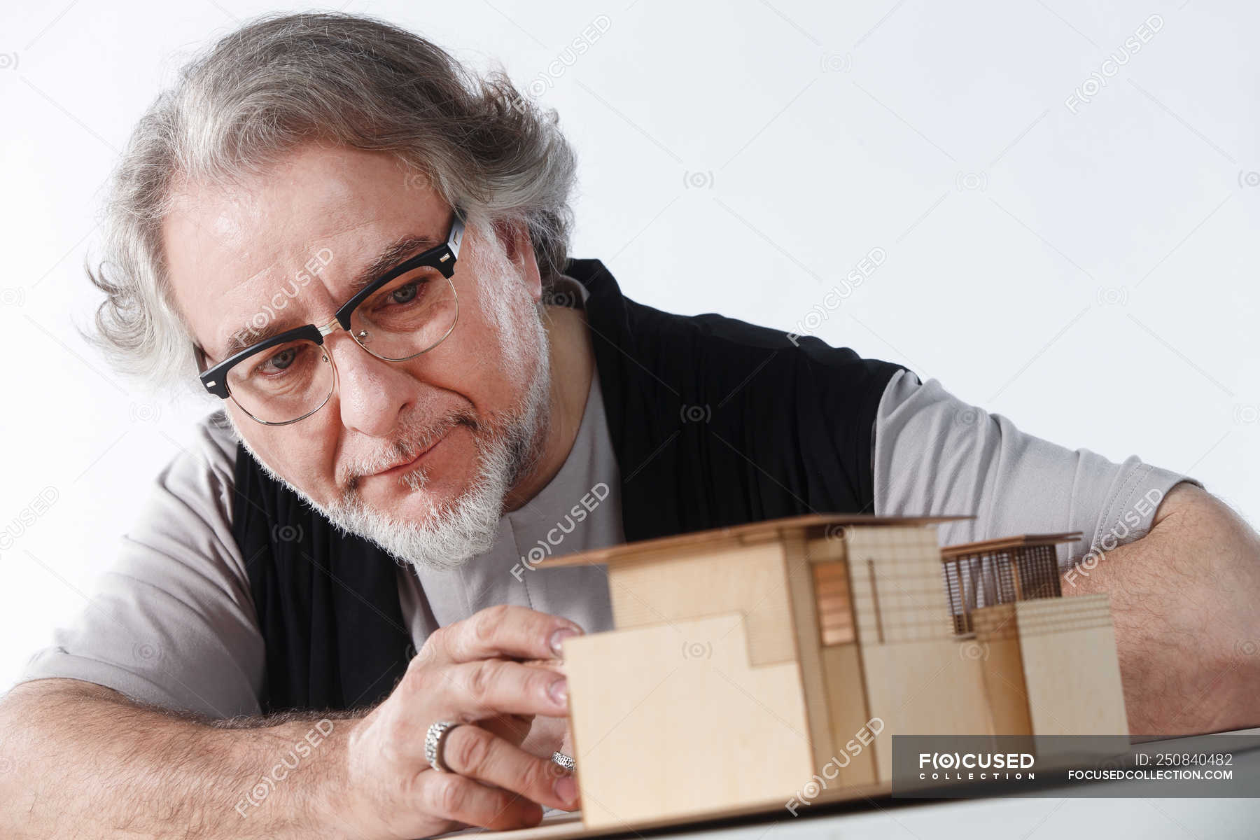 Serious focused professional mature architect in eyeglasses working ...