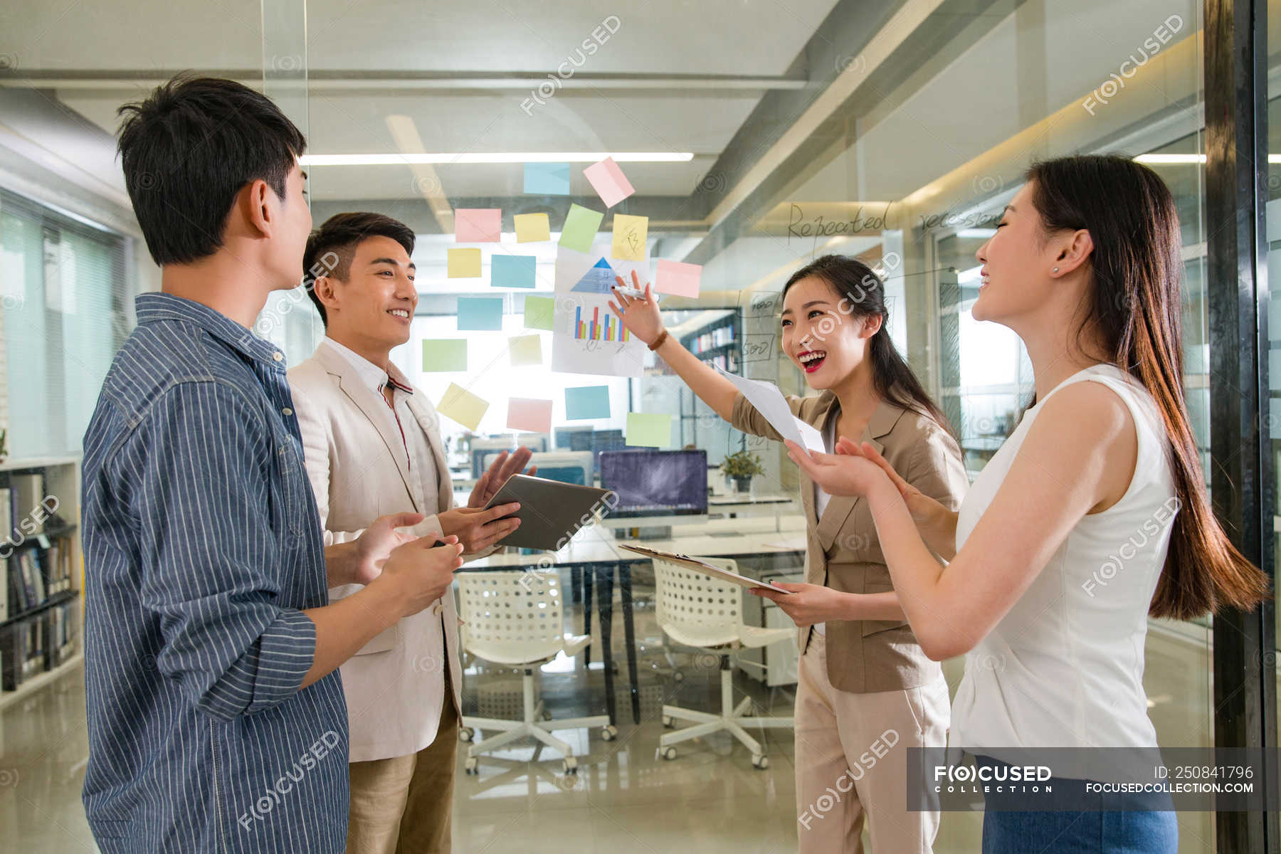 Side view of professional smiling young asian business people talking ... Side view of professional smiling young asian business people talking ...