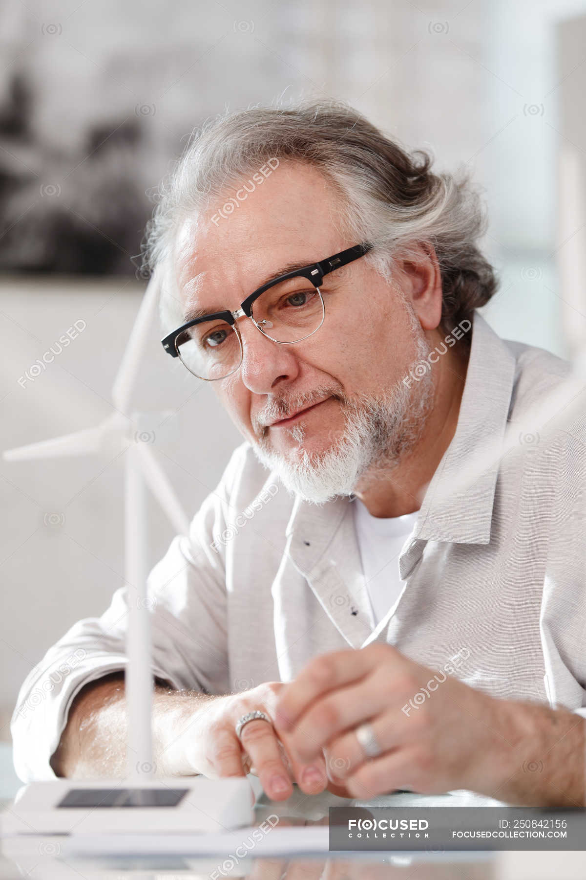 Professional focused mature architect in eyeglasses working with ...