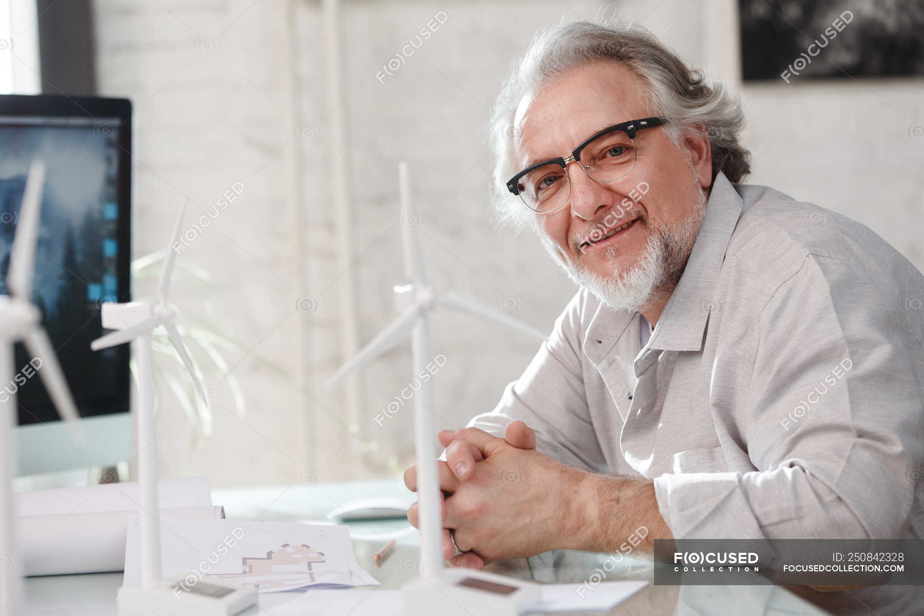 Professional mature architect in eyeglasses working with windmills ...