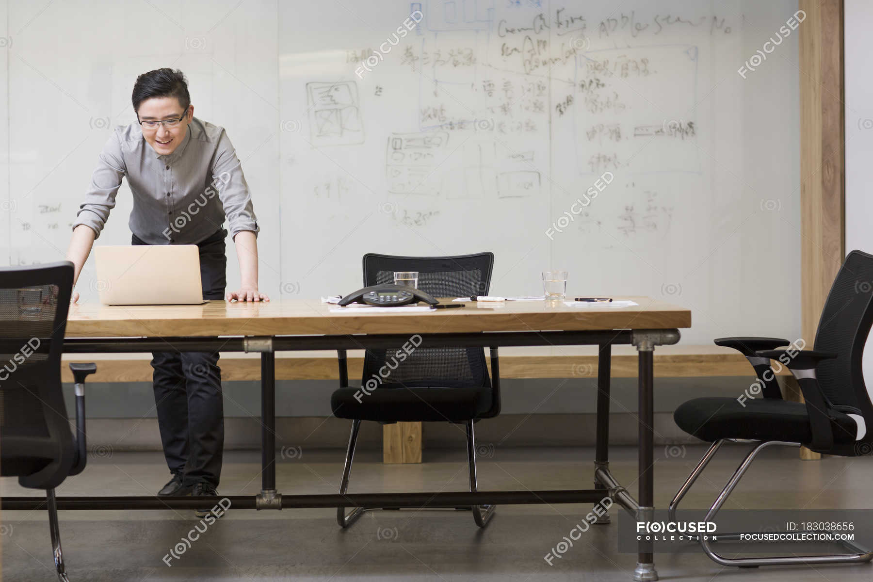 Chinese computer programmer using laptop in board room — Chinese ...