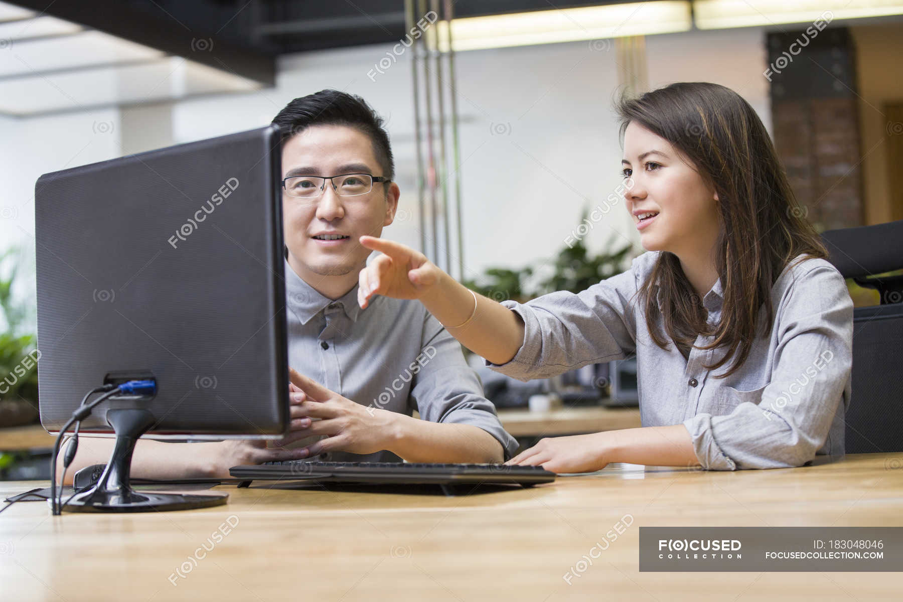 Chinese IT workers using computer in office — Gesturing, programmers ...