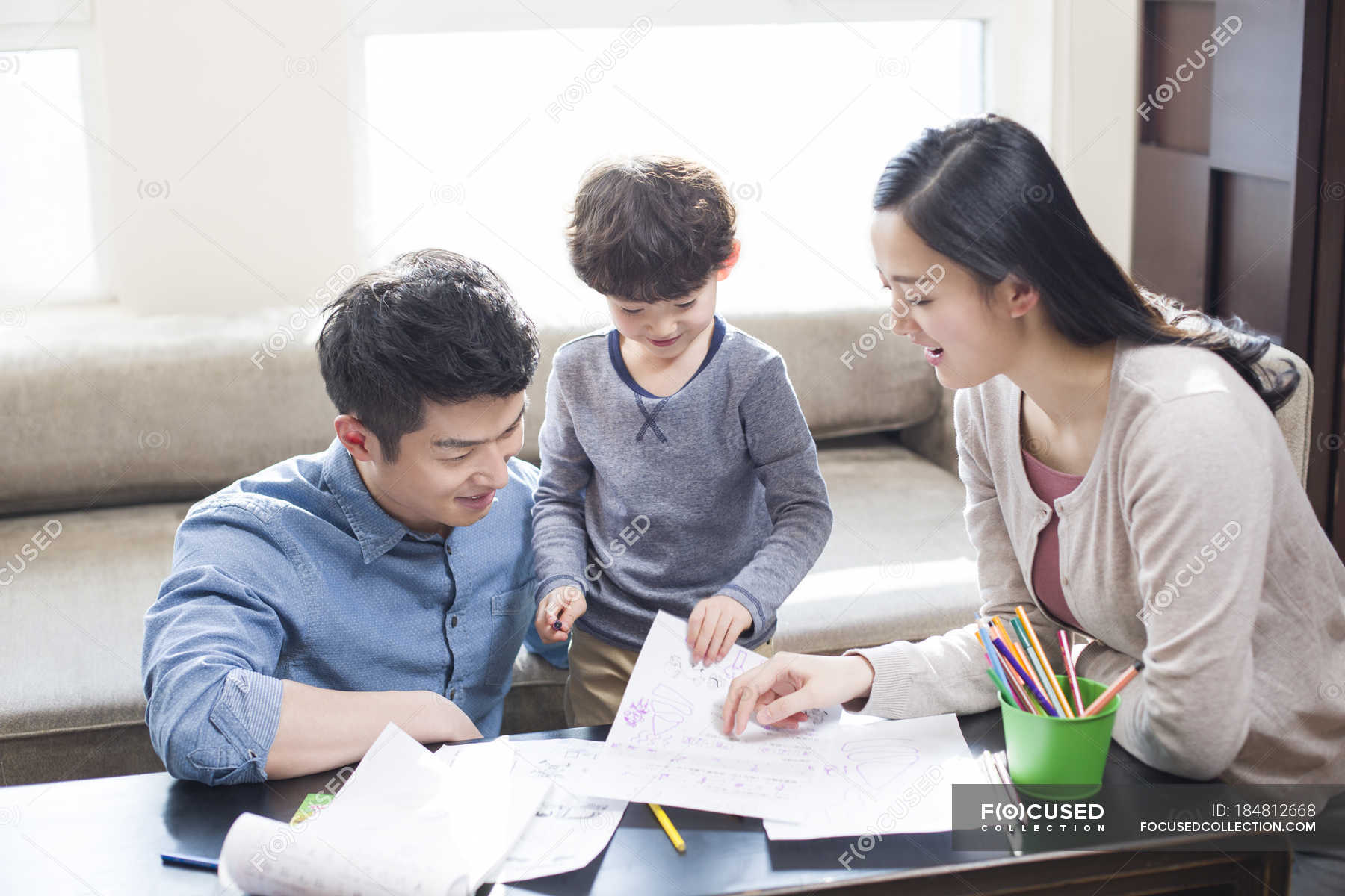 Chinese parents helping son with homework — interior, kid - Stock Photo | #184812668