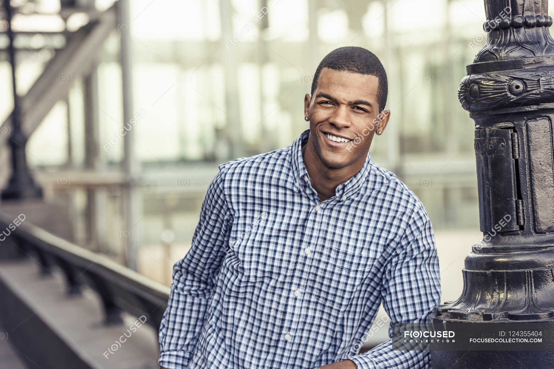 Man leaning on a railing in a city park — urban scene, shirt - Stock ...