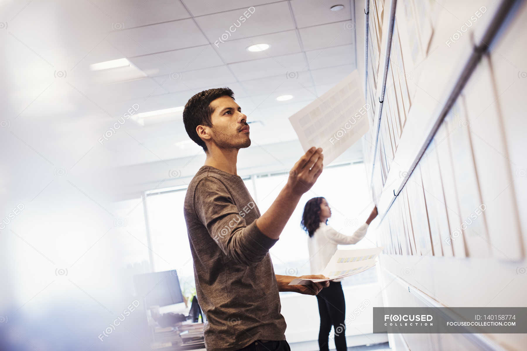 Woman and man adding paper to display — message, partnership - Stock ...