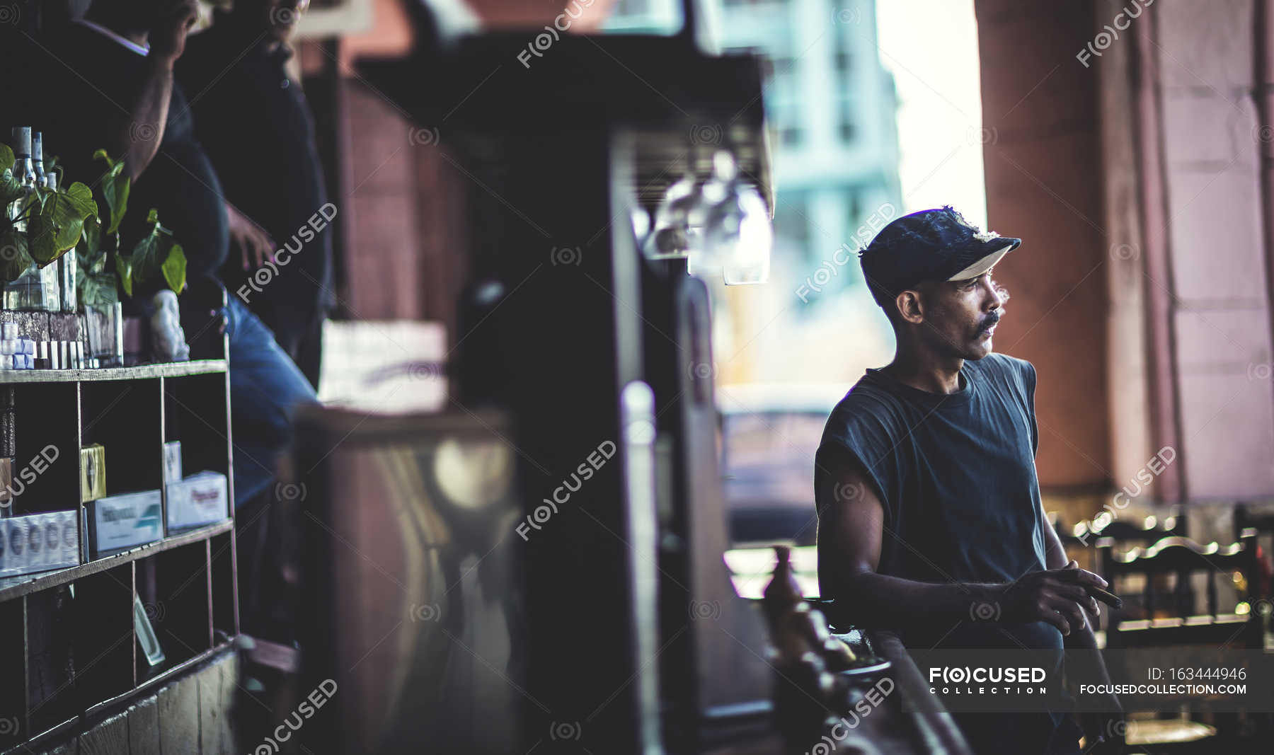 Man leaning on bar in cafe — cuban cigar, cool - Stock Photo | #163444946
